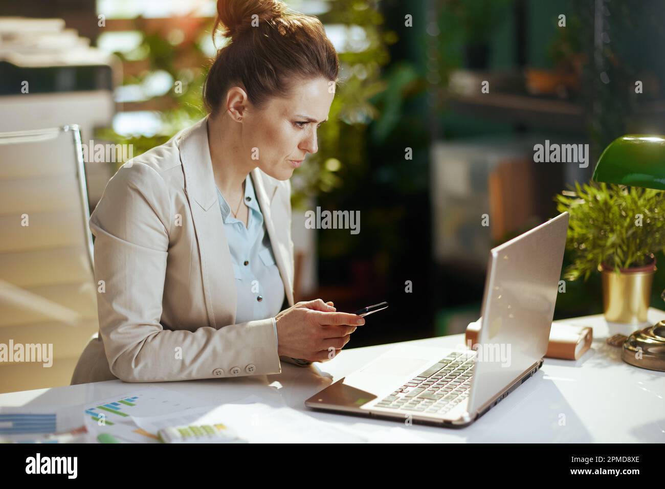 modern accountant woman in a light business suit in modern green office ...