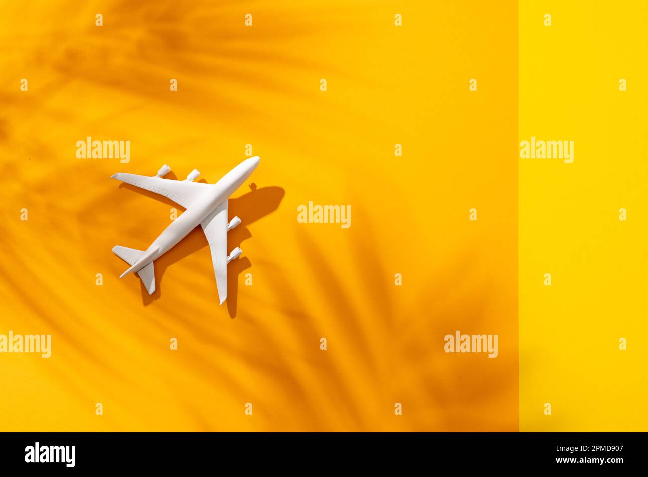 Close up of airplane model with leaves shadows on yellow background ...