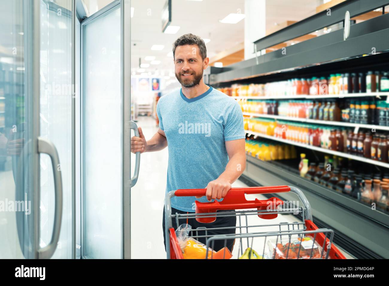 Man with shopping cart in a grocery store Stock Photo - Alamy