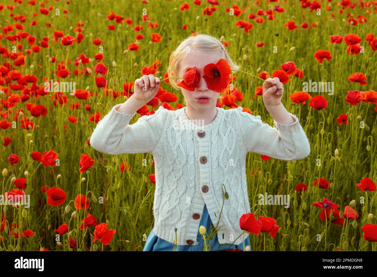 Girl with poppies eyes. Child girl resting in a poppies spring meadow ...