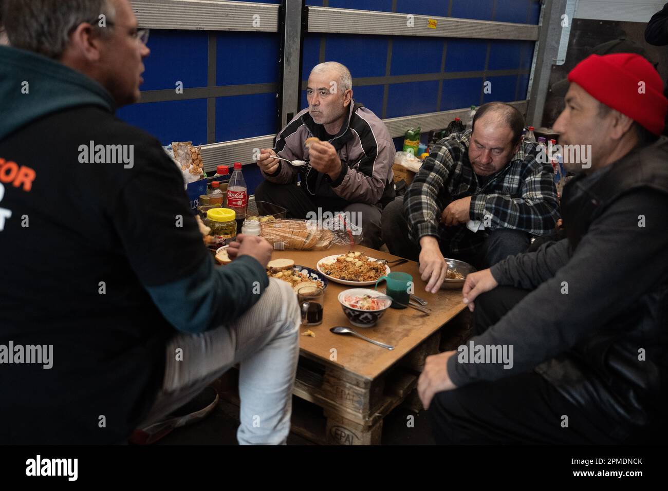 Weiterstadt, Germany. 12th Apr, 2023. Men from Uzbekistan eat with ...