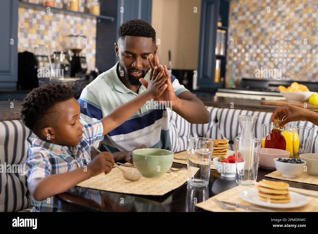 African american father and son giving high-five to each other while ...