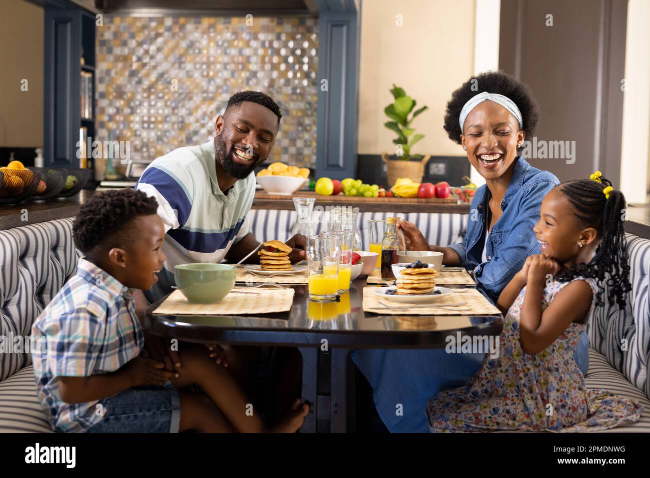 Cheerful african american parents and children talking while having ...