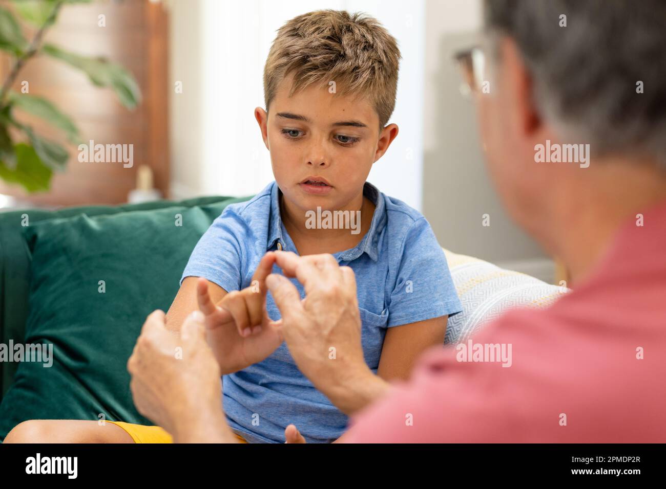 Caucasian grandfather teaching sign language to cute grandson while ...