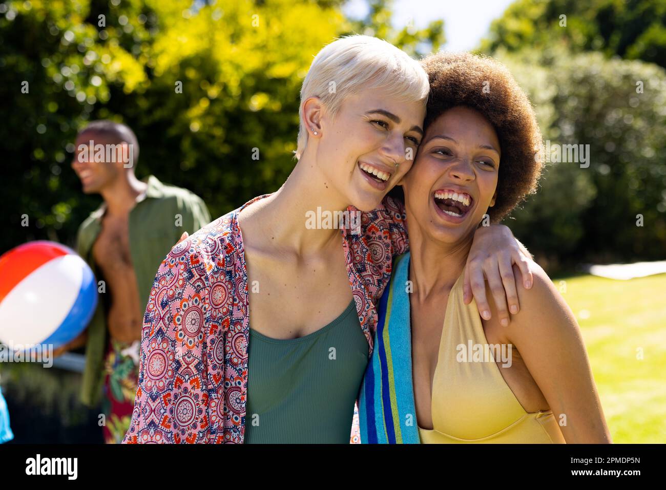 Happy diverse female friends having pool party, embracing and smiling ...