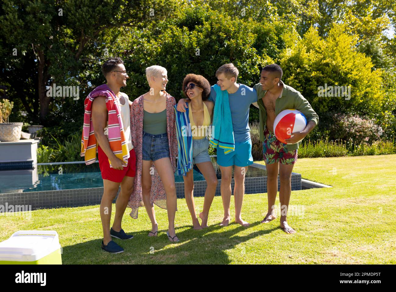 Happy diverse group of friends having pool party, embracing and smiling ...