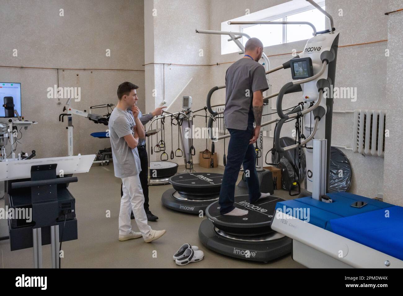 A man works on physical rehabilitation equipment in the presence of ...
