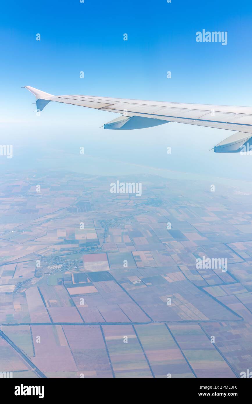 Aerial view from airplane window above green ground. View from the ...