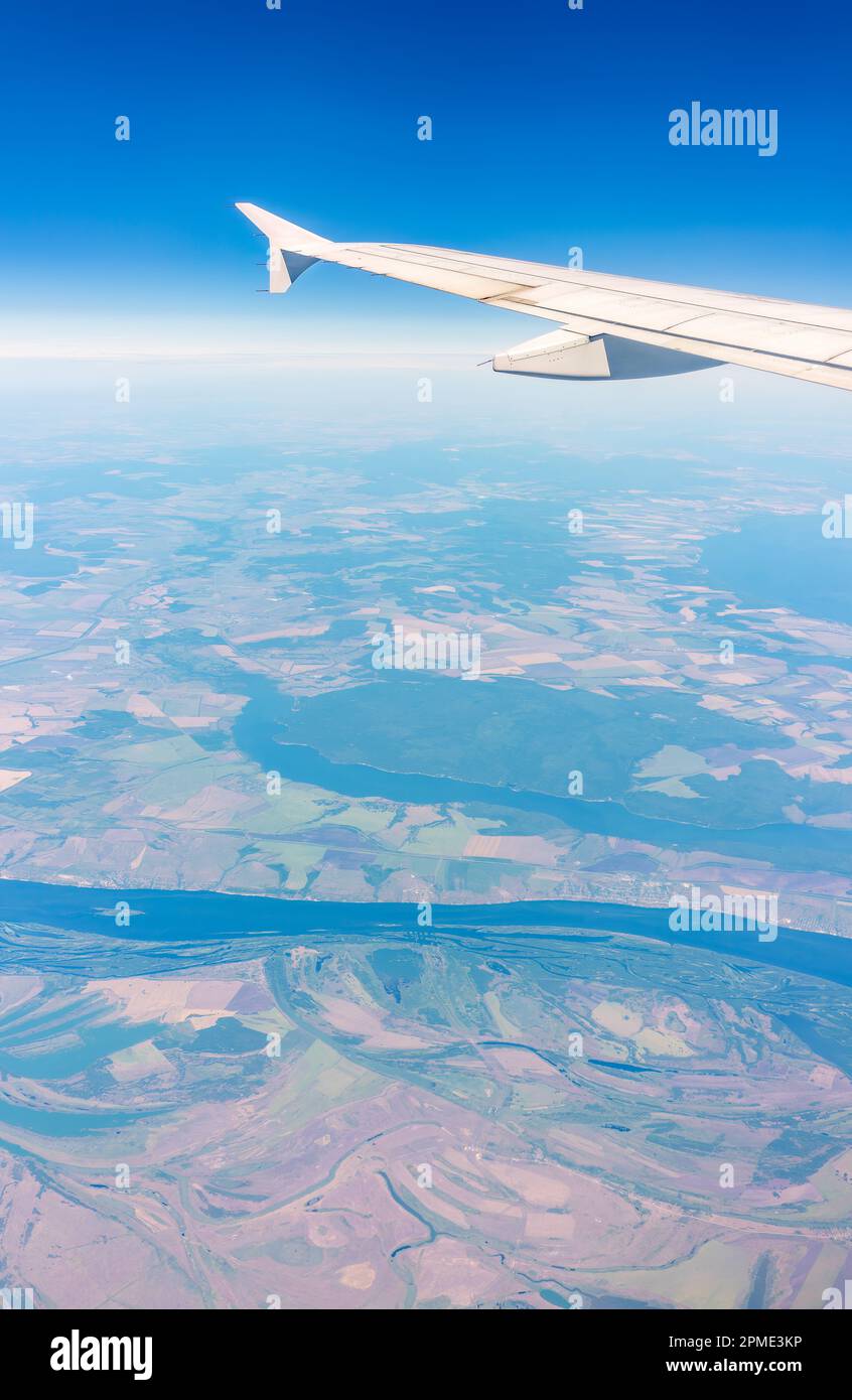 Aerial view from airplane window above green ground. View from the ...