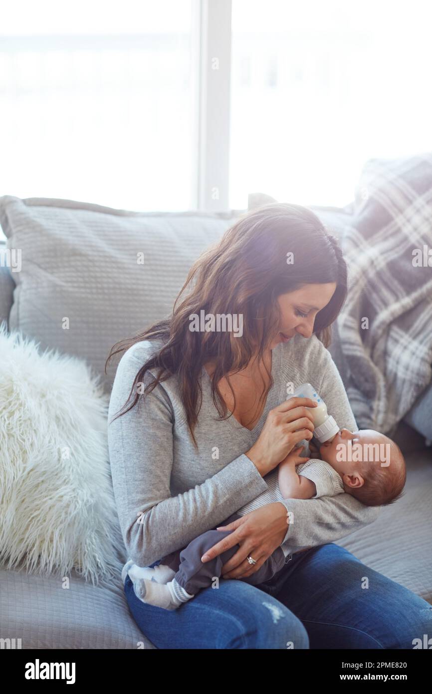 Hes happiest when fed. a mother feeding her newborn baby Stock Photo - Alamy
