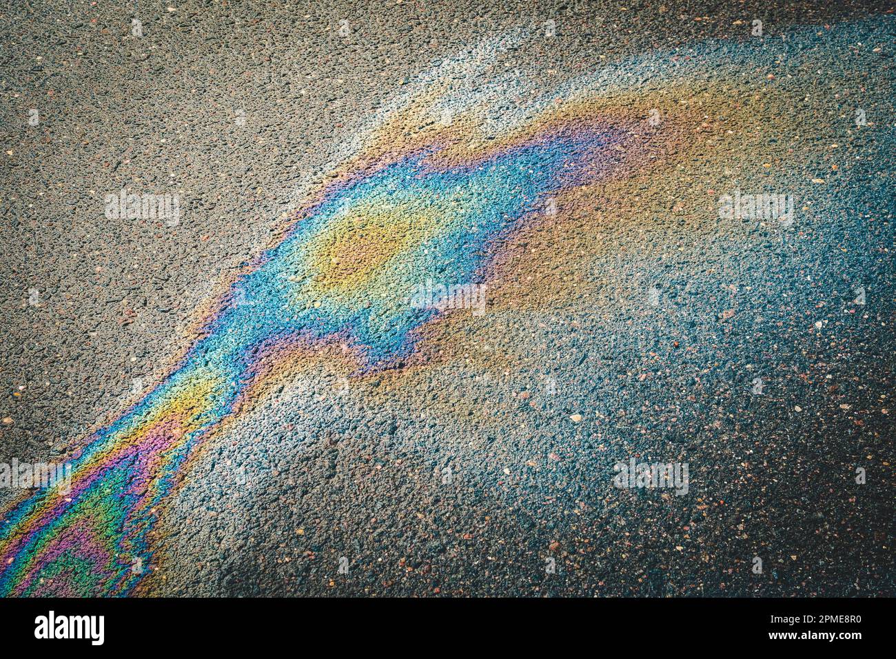 Oil stain on the asphalt, rainbow-shaped colored gasoline stains on an ...
