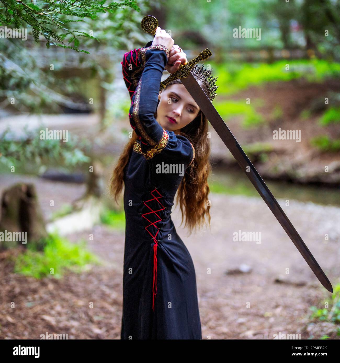 Young Woman in Fairytale Queen Costume with Crown Wielding Large ...