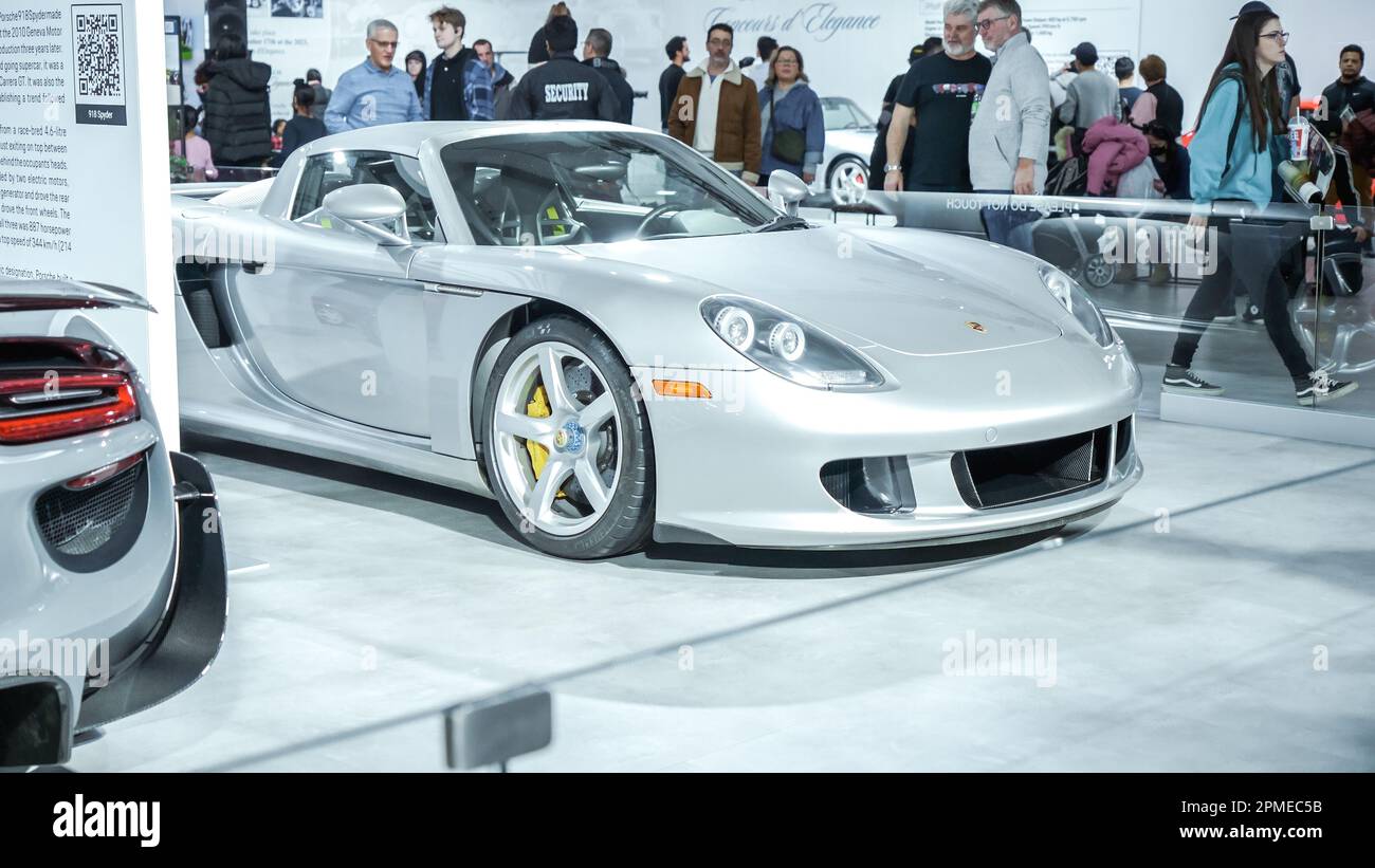 Crowds looking at new car models at Auto show. Porsche Spyder car on ...