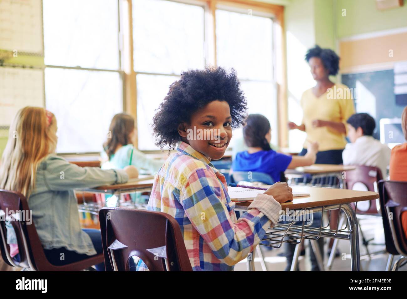 I learn so much in class. a young boy sitting in class with his teacher ...