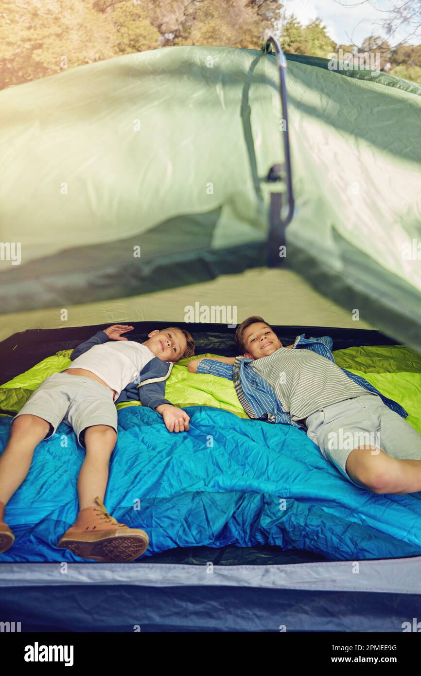 Boys will be boys. two young brothers lying in their tent Stock Photo ...