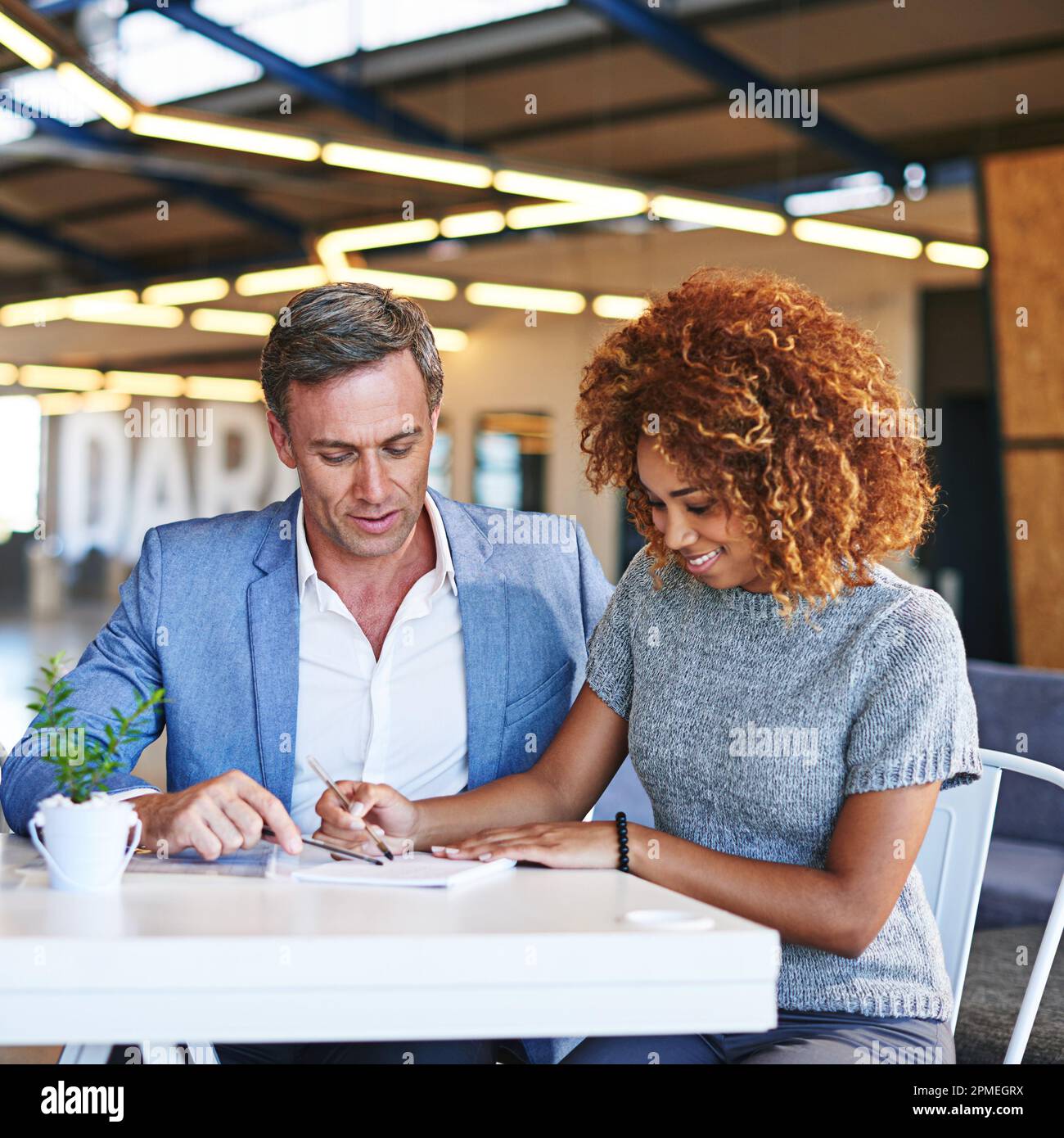 Mentoring his young staff. smiling colleagues working together in an ...