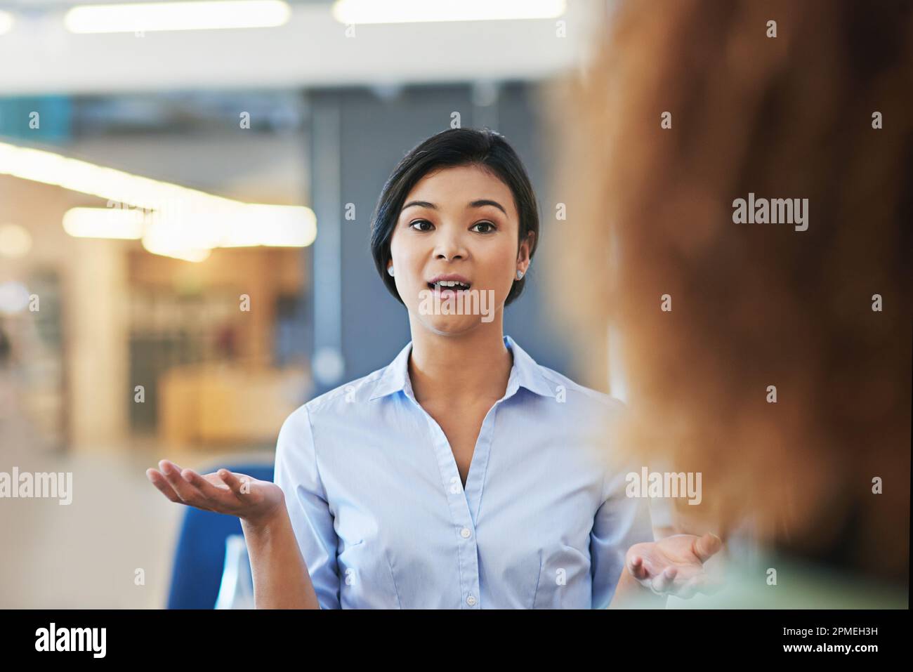 She makes some good points. a coworkers talking together in an office ...