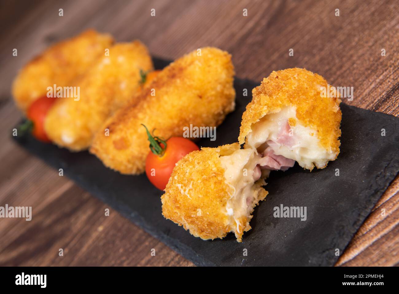 Homemade traditional Spanish croquettes or croquetas on a black plate ...