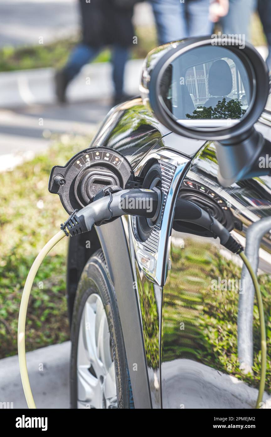 Electric car while charging at a city power station Stock Photo - Alamy