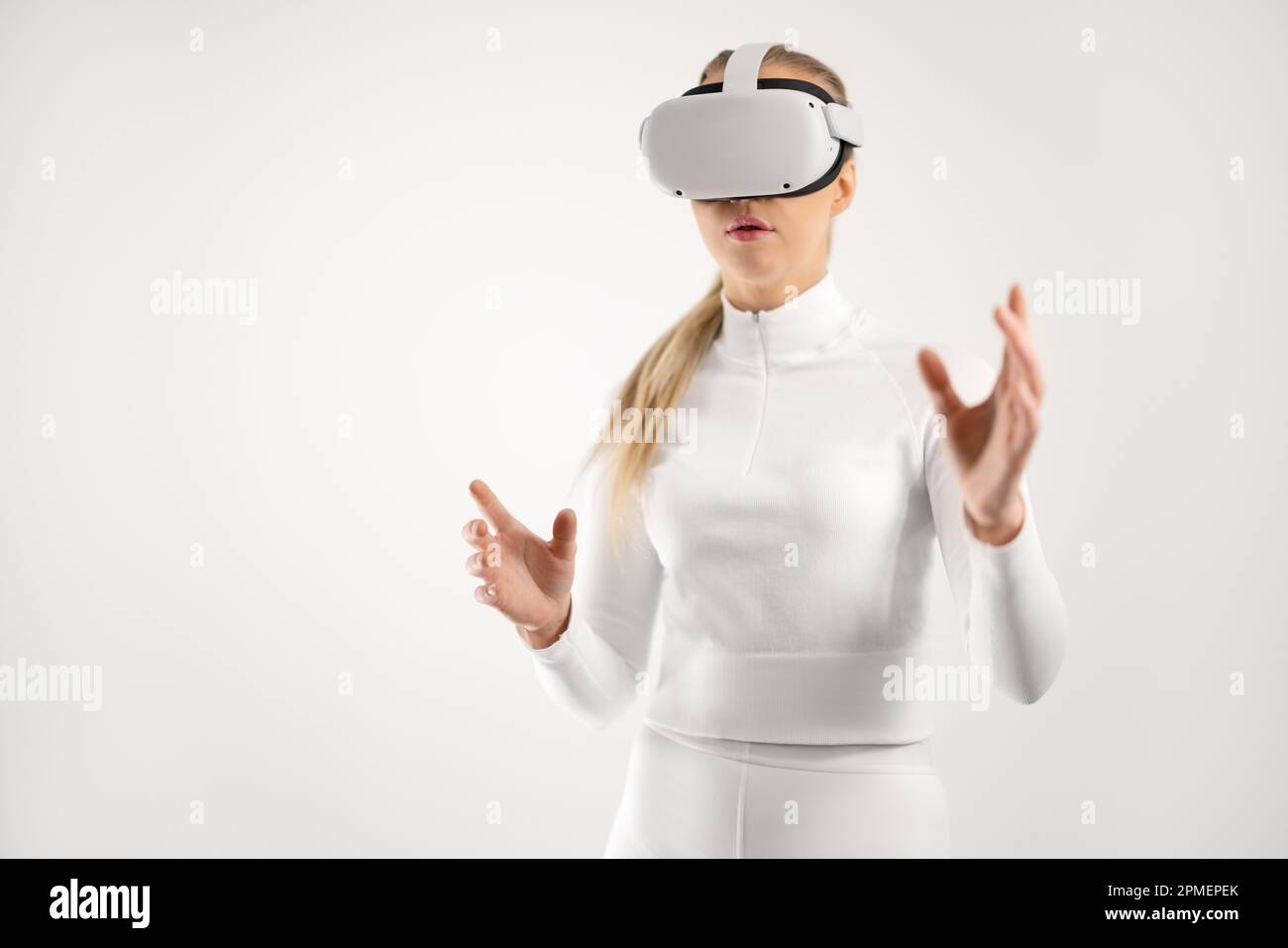 Focused woman in white clothes wearing VR glasses equipment for virtual ...