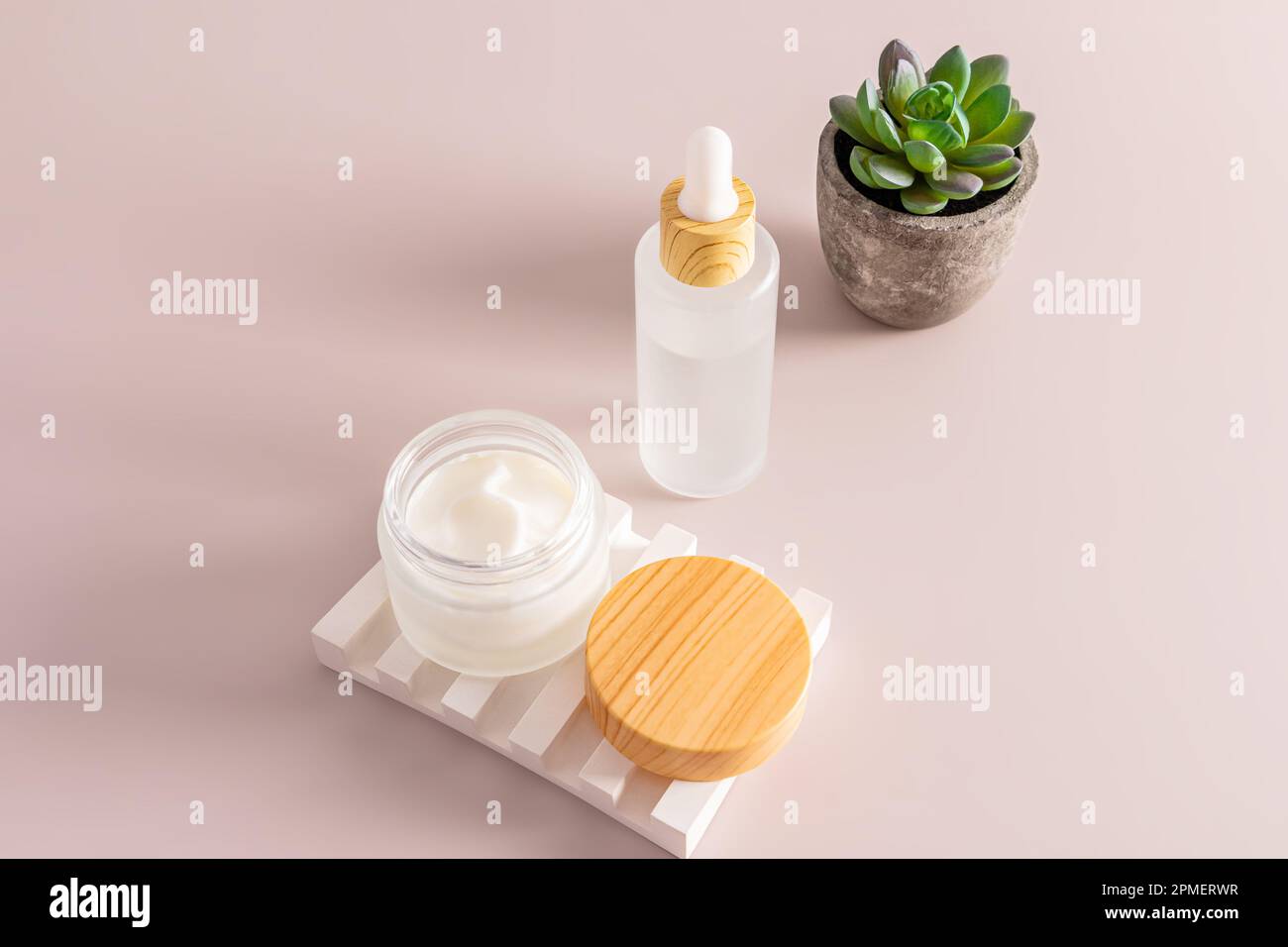 an open matte jar with moisturizer on a plaster relief podium and serum ...