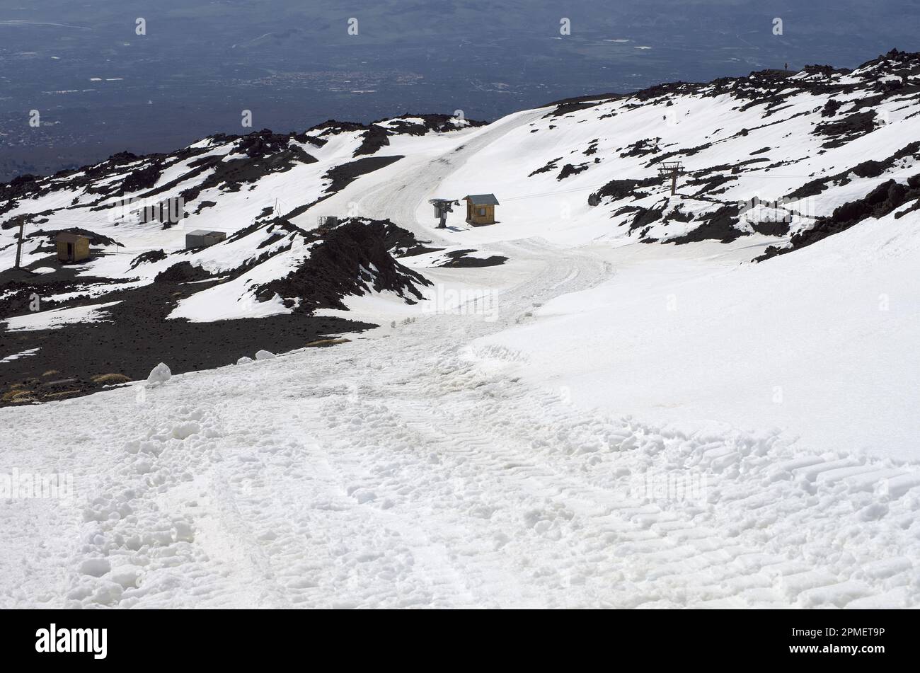 tracks of snow groomer on a steep slope snowy of Etna National Park ...