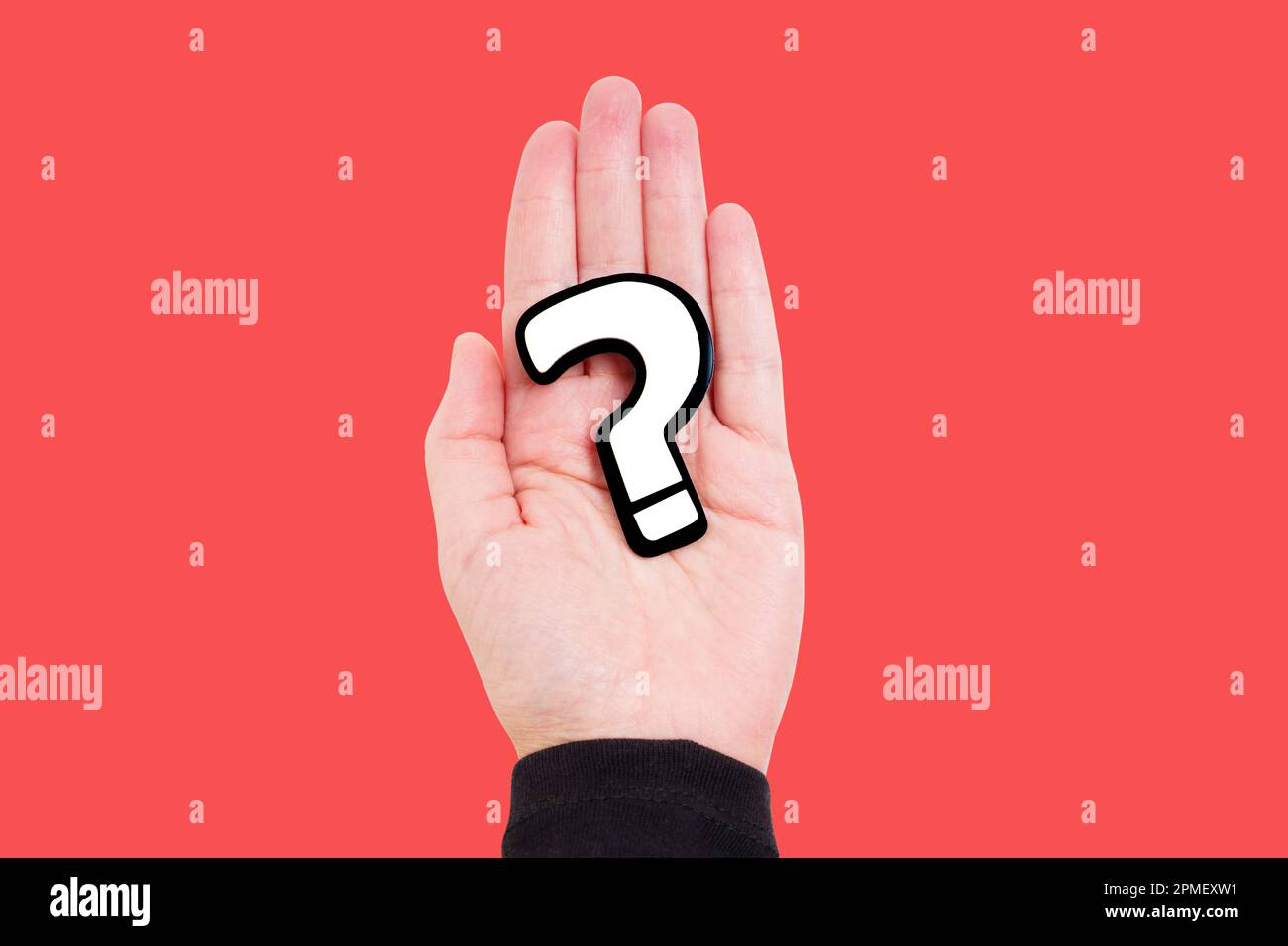 Crop view of a female hand holding a large white plastic question mark ...