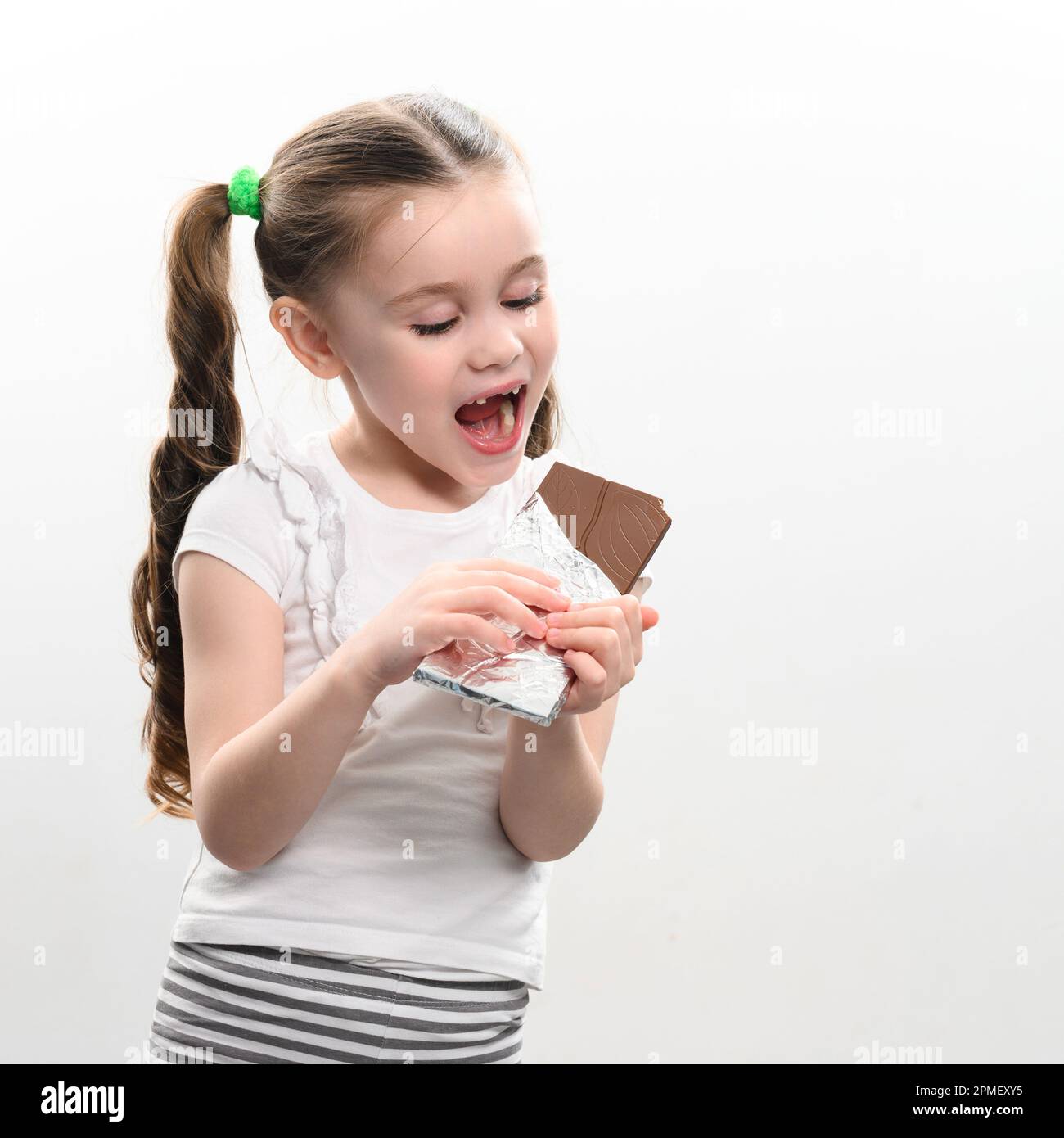 A happy and smiling little girl has a chocolate, portrait of a child ...