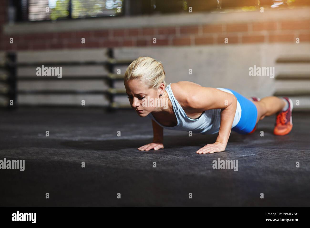 Every workout counts. a young woman doing pushups in a gym Stock Photo ...