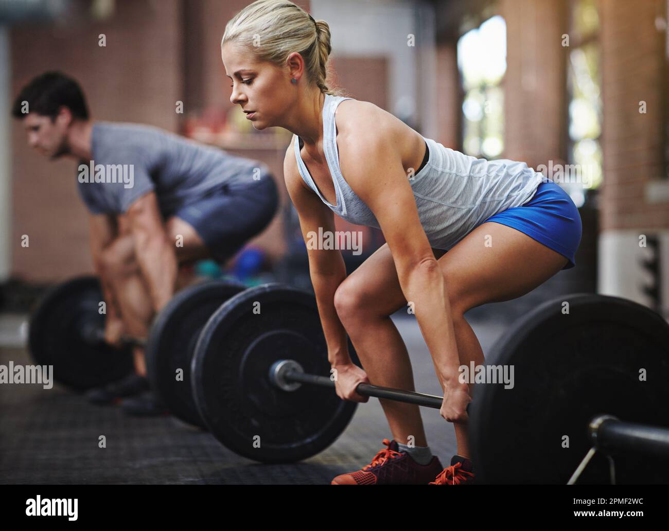 She can compete with anyone. two people lifting weights in a gym Stock ...