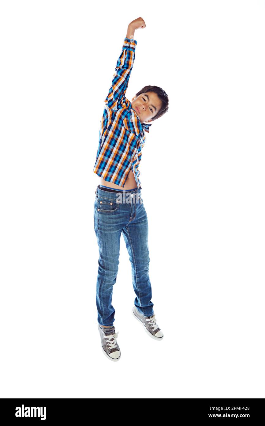 Way to grow. Studio shot of a young boy jumping for joy against a white ...