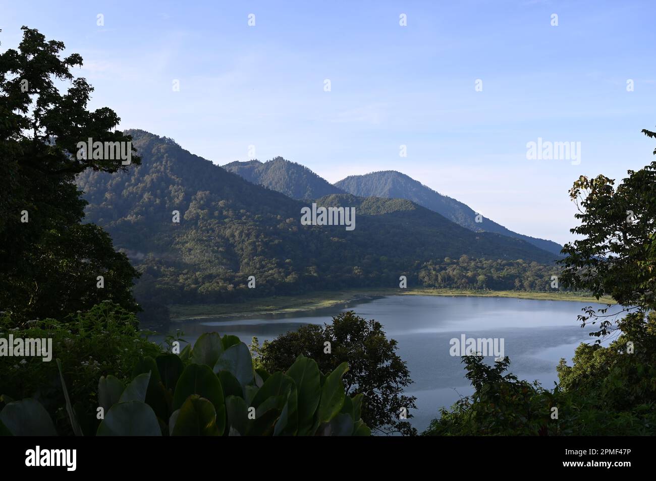 Bright morning view of Tamblingan Lake, Bali, with mountains and ...