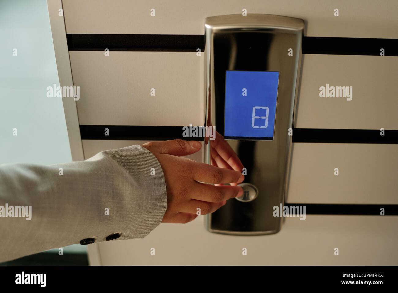 Close-up of businesswoman pushing button of elevator and waiting for it ...