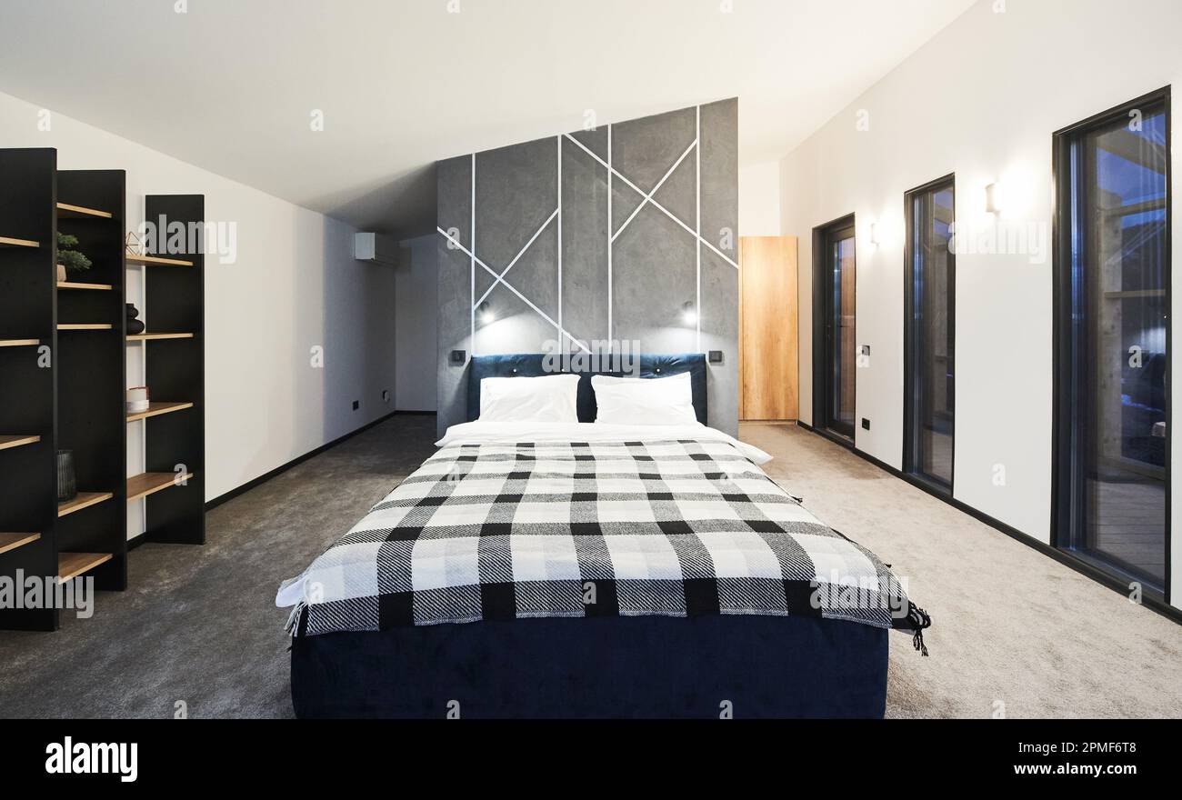 Minimalist interior of bedroom with big bed and wooden brown shelves ...