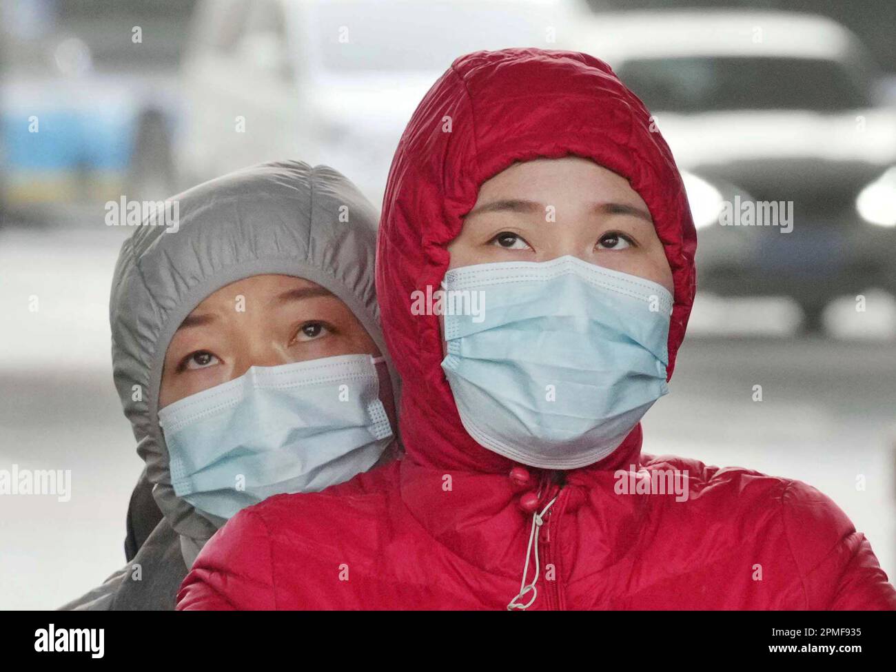 People wear a rain suit and face mask to protect themselves from yellow ...