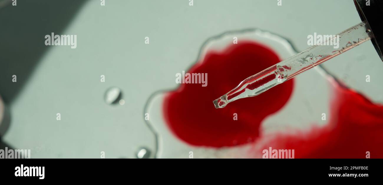 Red liquid with a pipette in the form of a spot in the container ...