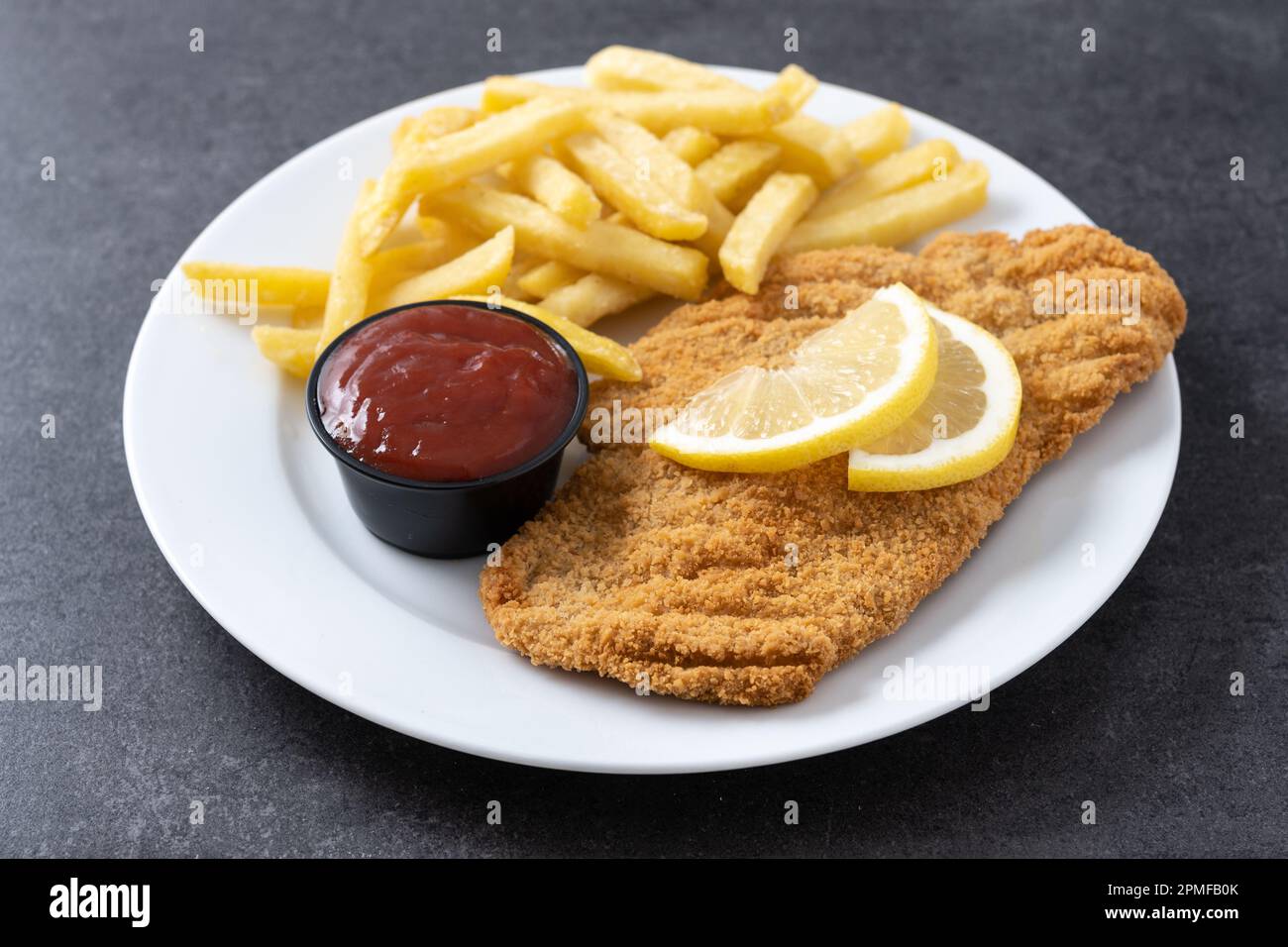 Wiener schnitzel with fried potatoes on black slate surface.typical vienna food Stock Photo - Alamy