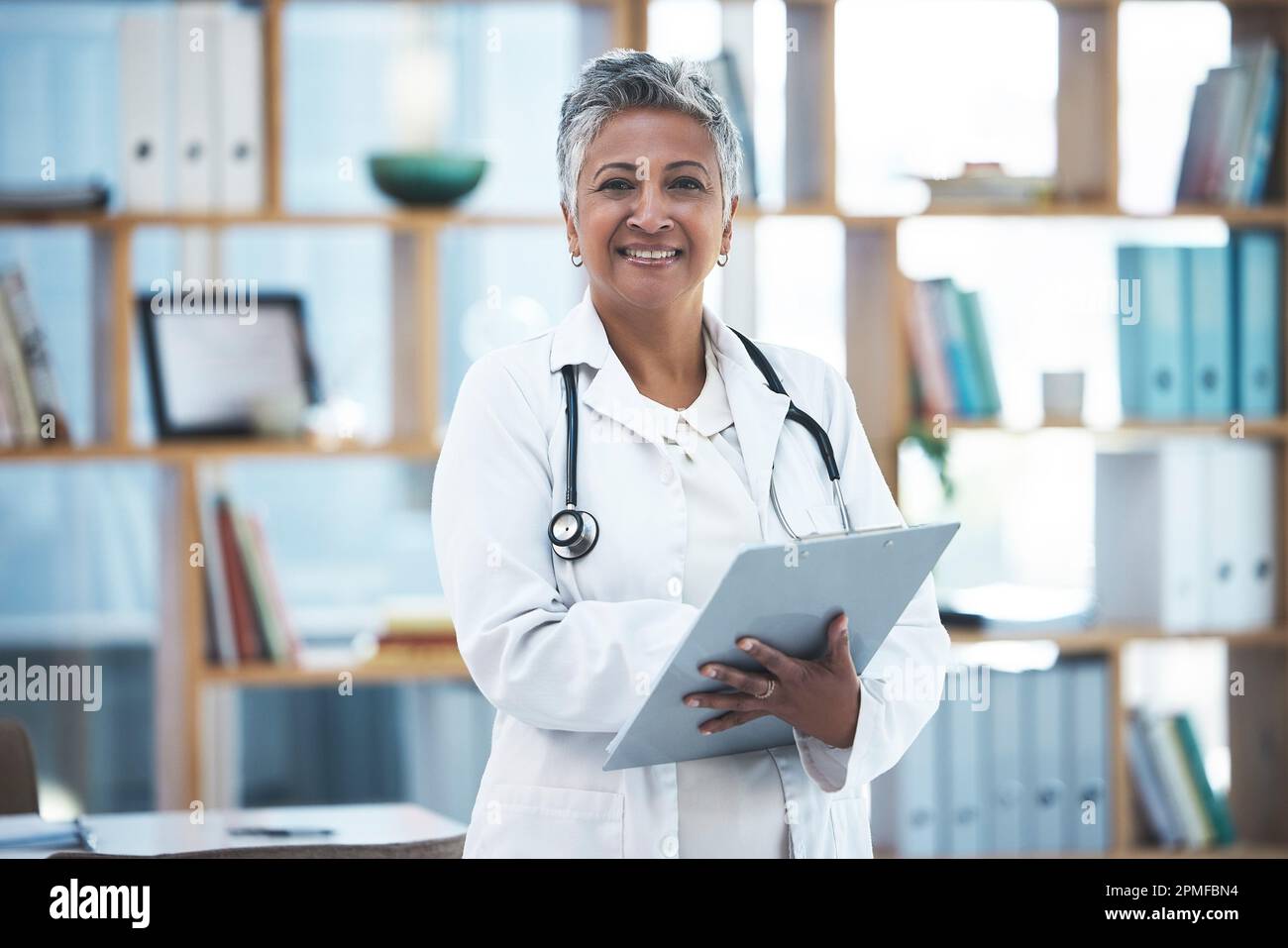 Senior woman doctor, portrait and checklist in clinic for inspection, healthcare paperwork or ...