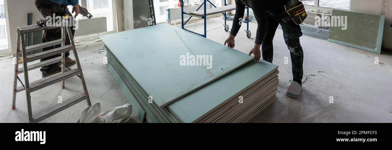 Workers fitting panel into frame of ceiling Stock Photo - Alamy