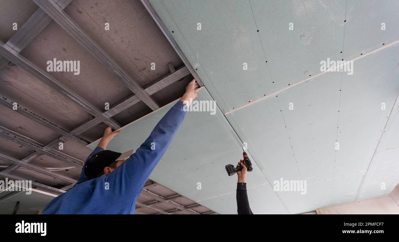Drywall Installers. Men holding a gypsum board figured cut Stock Photo ...
