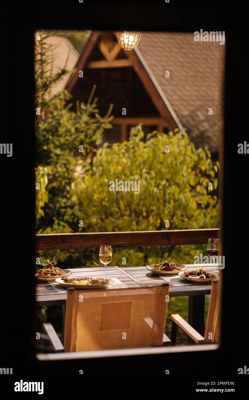 Outdoor dinner on summer terrace. Served table with several dishes ...