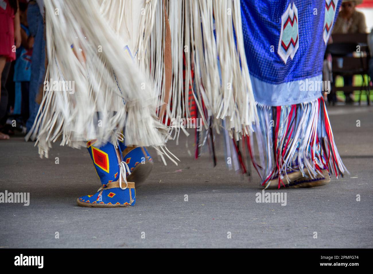 Native American people wearing a traditional blue costume and boots are ...