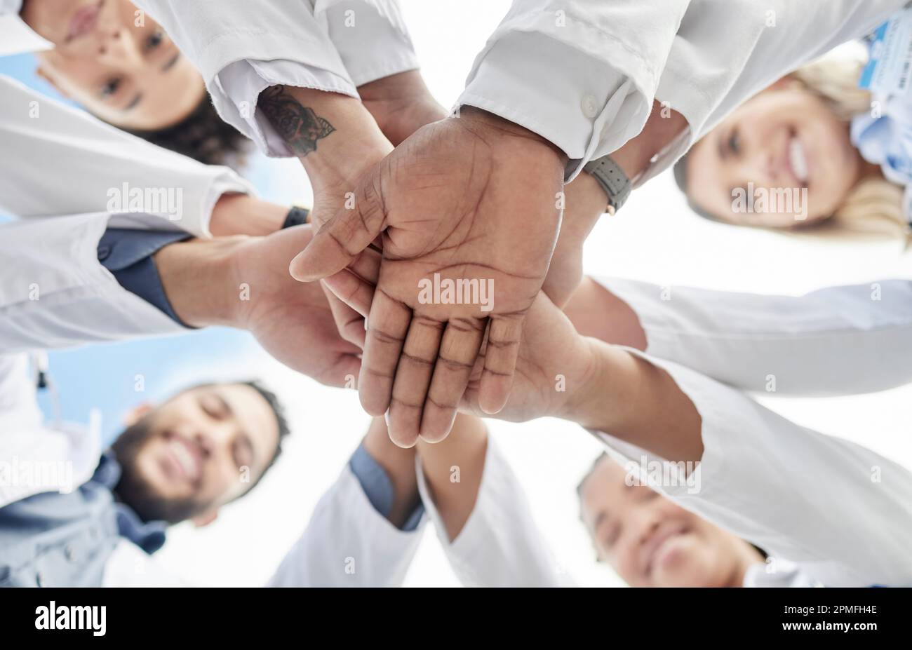 Hand stack, doctors and below group with smile for motivation, success and team building in ...