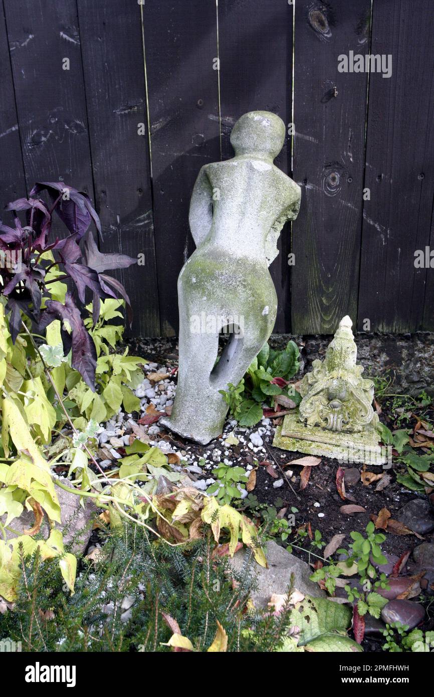 Ancient style worn decorative sculpture abandoned in the garden ...
