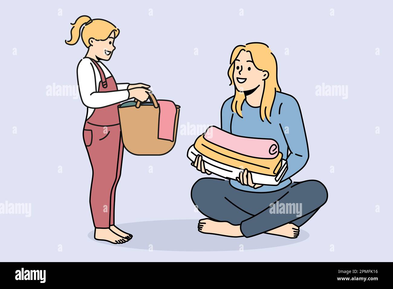 Smiling little girl child help mom doing laundry at home. Happy mother with small daughter ...