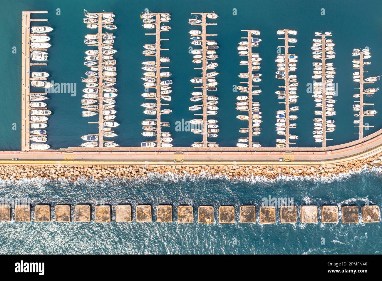 Yachts, sailboats and motorboats in a marina in Spain. On turquoise ...