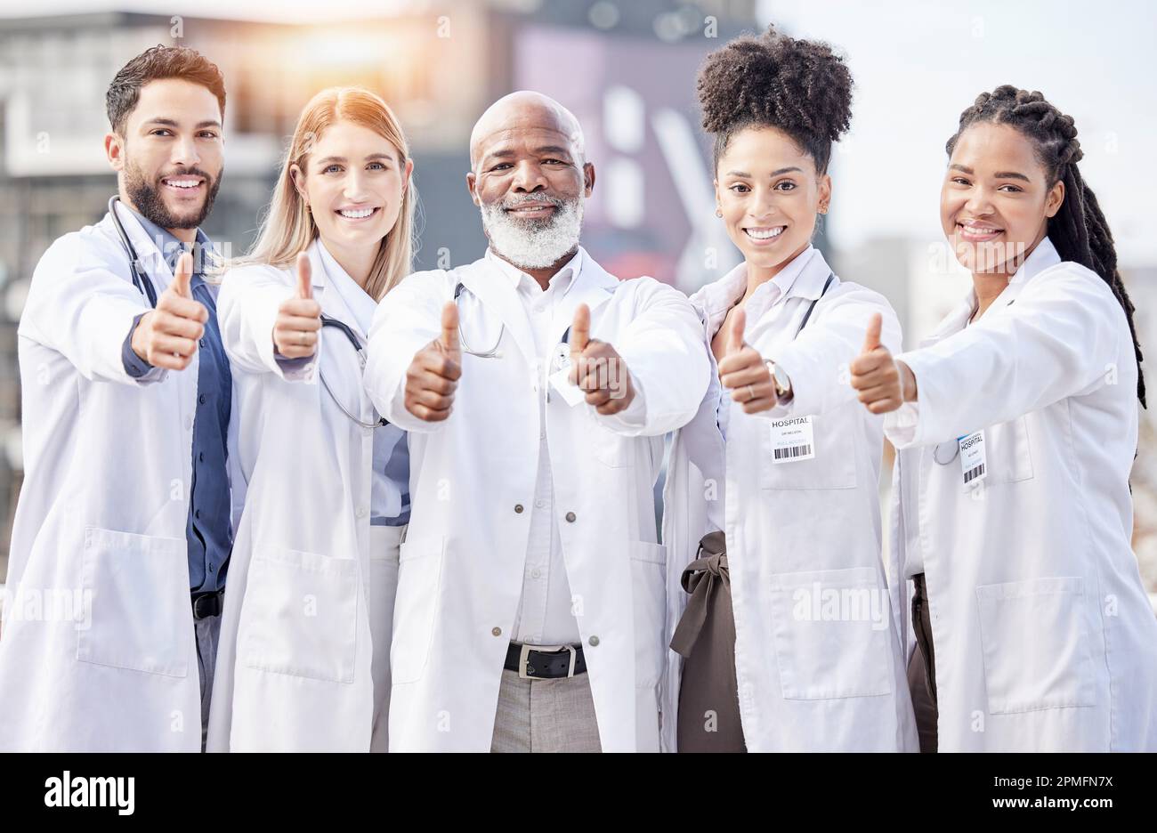 Portrait, collaboration and thumbs up with a team of doctors standing ...