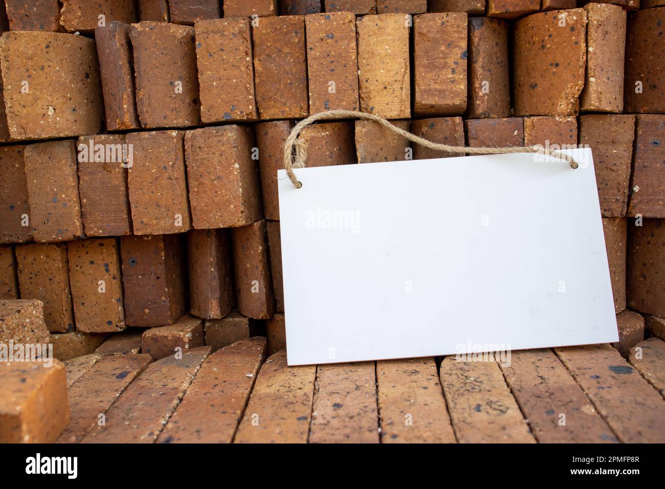 pile of stacked orange bricks with white hanging picture sign with ...