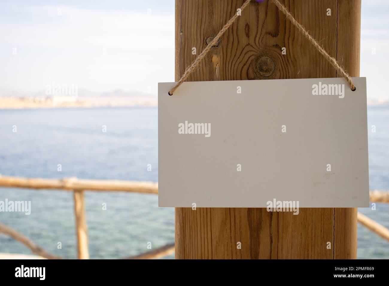 vertical wooden post with the blue sea in the background and a white ...