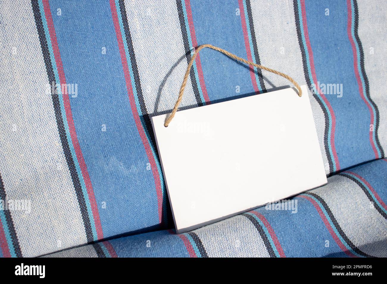 white hanging picture sign on a blue and white sun bed material with ...